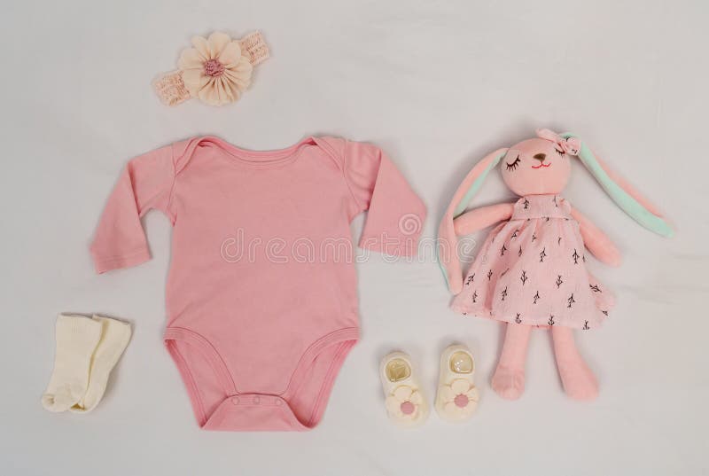 Set of Baby Clothes and Toy and Accessories on White Bed Stock Photo ...