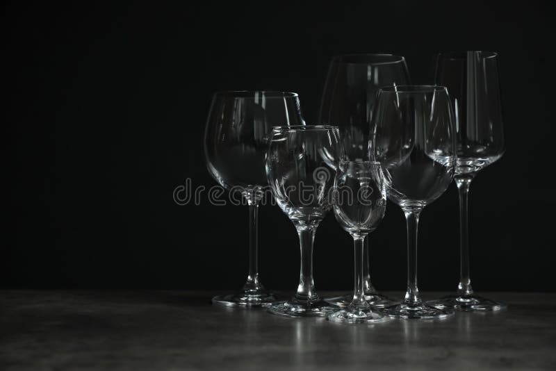 Set of Bar Glassware on Table Against Dark Background Stock Photo ...