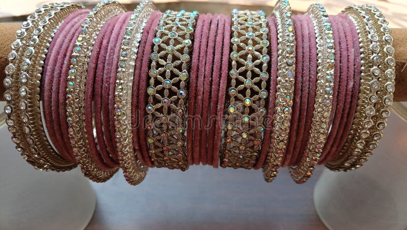 A Set of Beautiful Designed Bangles Displayed on a Cylindrical Holder ...