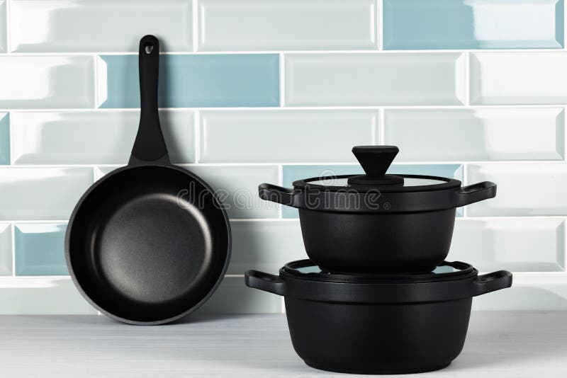 Set of Black Cookware on Kitchen Counter Stock Image - Image of closeup ...