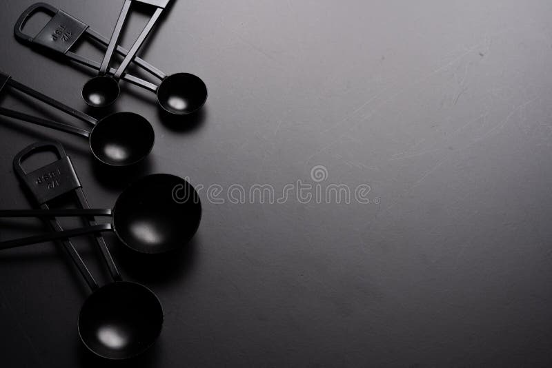 A Set of Black Measuring Spoon on Black Background Stock Photo - Image ...