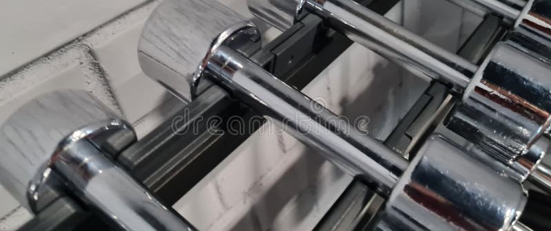 Set of Chrome Dumbbells of Different Weights in Its Support in Gym ...
