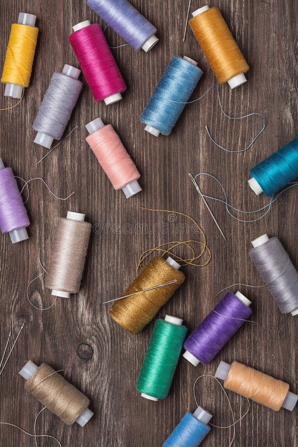 Set of Coils with Multi-colored Threads. Needles on Wooden Background ...