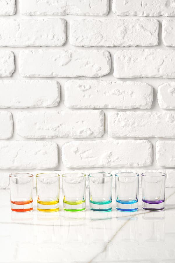 Set of Colored Vodka Glasses Against White Brick Wall Stock Photo ...