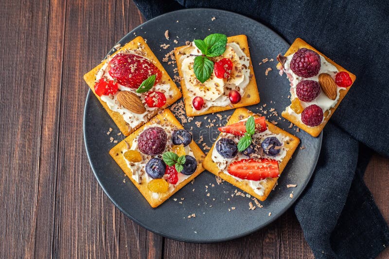 Set of Crackers with Various Fruit Close-up on Dark Wooden Table. Top ...
