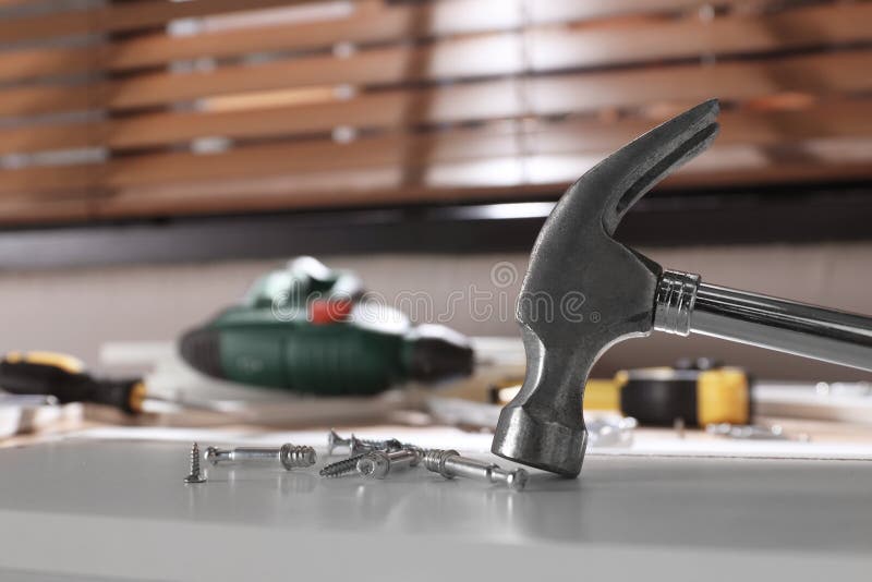 Set of Different Fasteners and Hammer on White Table Indoors. Furniture ...