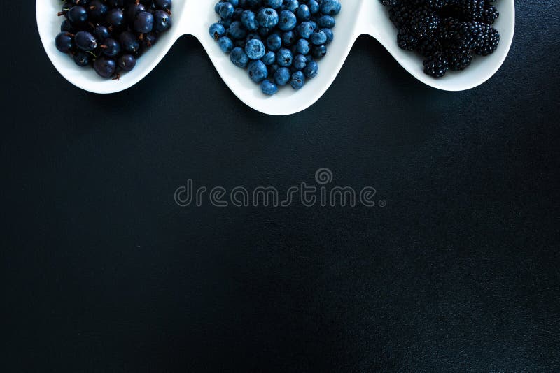 Set of Different Types of Black Berries in a White Plate on a Black ...