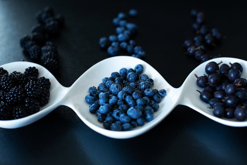 Set of Different Types of Black Berries in a White Plate on a Black ...