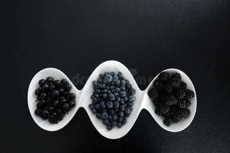Set of Different Types of Black Berries in a White Plate on a Black ...
