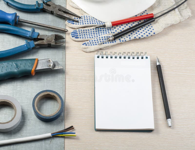 .Set of Electrical Tools, White Helmet and Notepad on Metallic ...