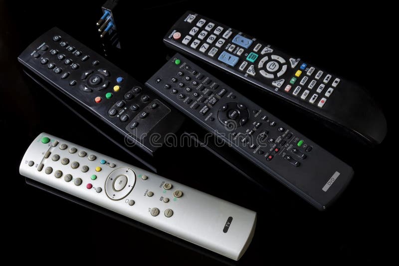 Set of Four Remote Controls on a Shiny Black Background with Reflection ...