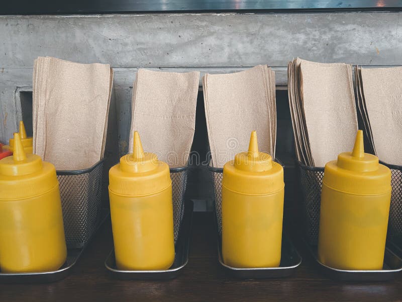 Set of Many Mustard in Yellow Bottle with Brown Tissue Paper Stock ...