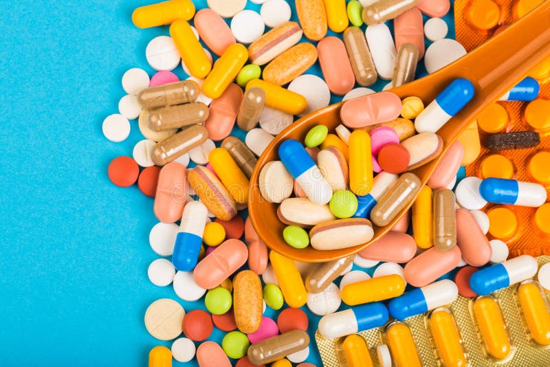 Set of Multi-colored Tablets and Capsules on a Blue Background Stock ...