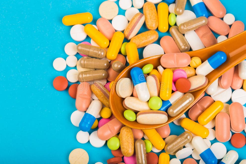 Set of Multi Coloured Tablets and Capsules on a Blue Background Stock ...