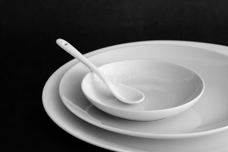 White Color Set of Plates with Spoon on Black Table Stock Photo - Image ...