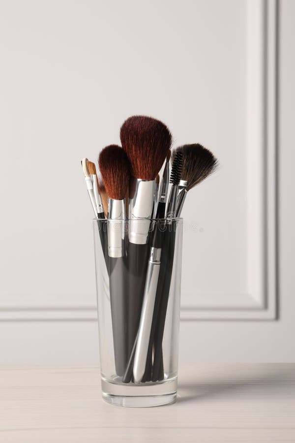 Set of Professional Makeup Brushes on Table Against White Background ...