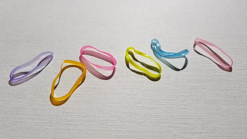 Set of Small Multi-colored Elastic Bands for Hair on a White Table ...