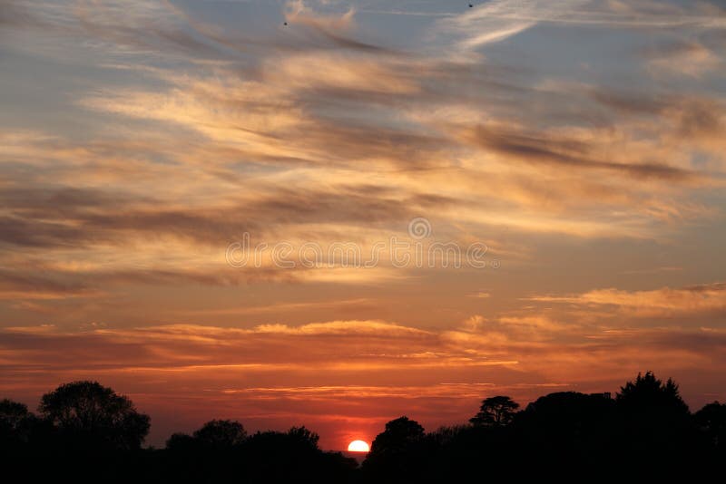An almost Set Sun in Cloudy Skies Stock Image - Image of blue ...