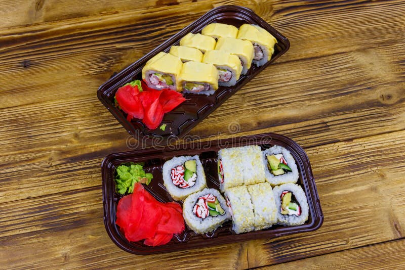 Set of Sushi Rolls in Plastic Boxes on Wooden Table. Top View. Sushi ...
