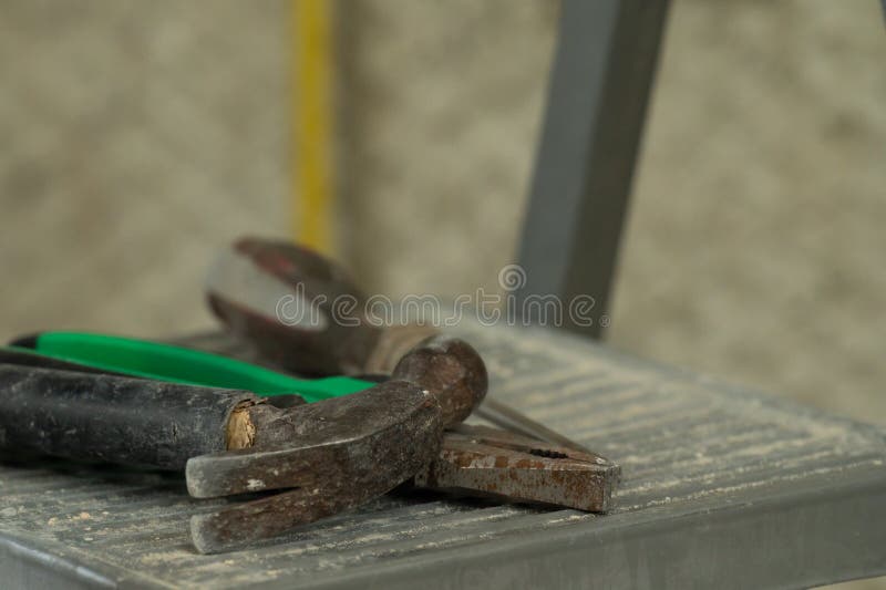 Set of Three Construction Tools on a Ladder Hammer, Pliers and ...