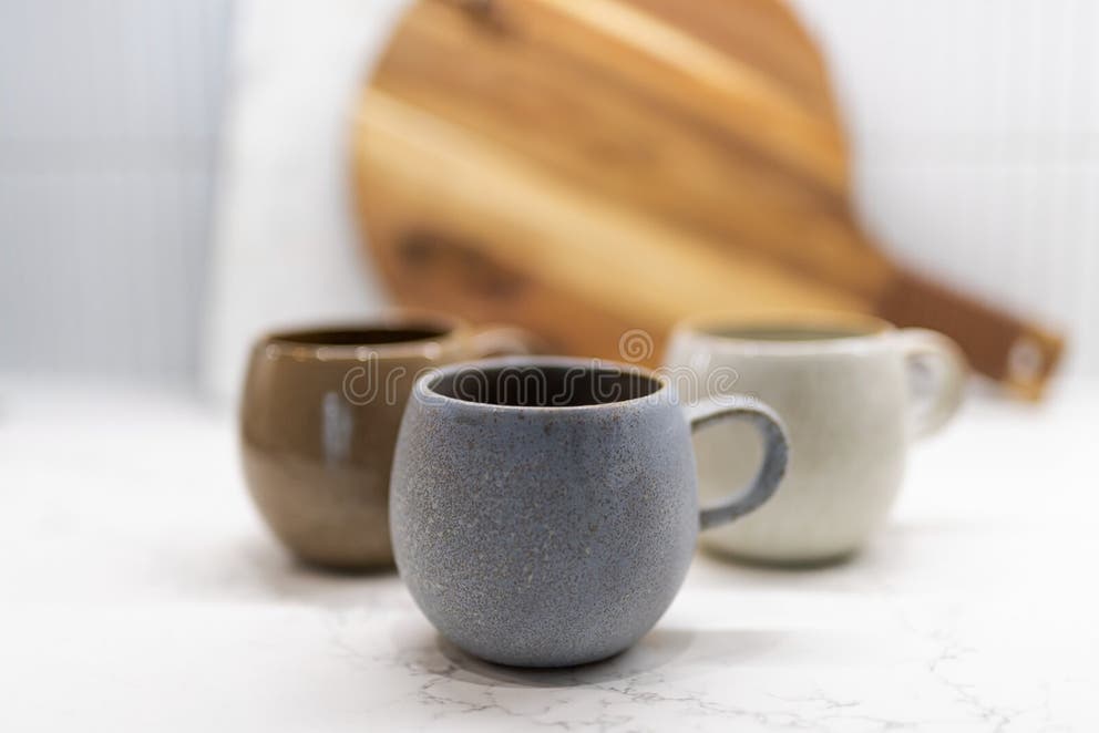 Set of Three Rustic Ceramic Mugs on Kitchen Counter. Stack of Handmade ...