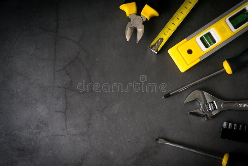 Yellow Hardware Tools on Black Concrete Background with Some Space for ...