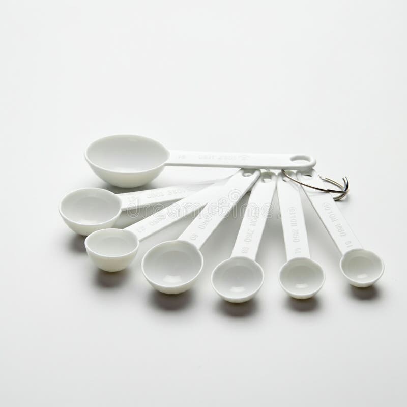 Set of White Plastic Measuring Spoons Arranged in a Fan Shape on a ...