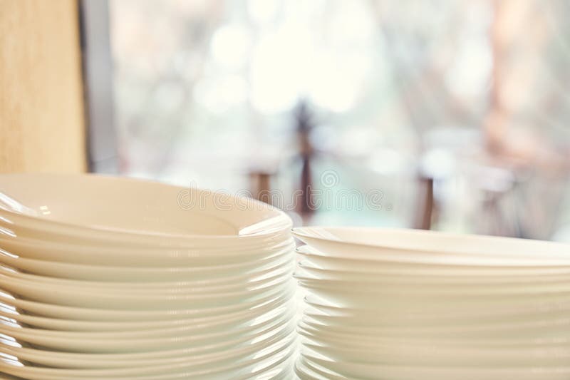 A Set of White Plates on the Table on a Light Blurred Background of the ...