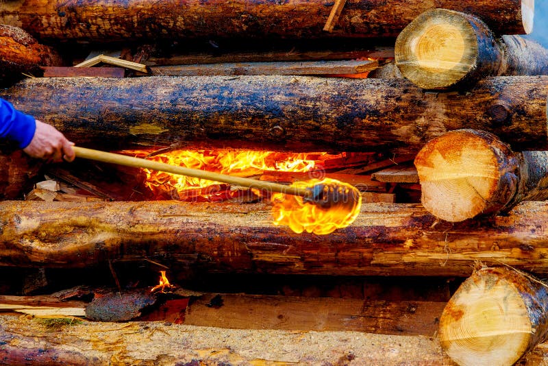 Setting Big Bonfire Made of Logs on Fire with Torch. Stock Photo ...