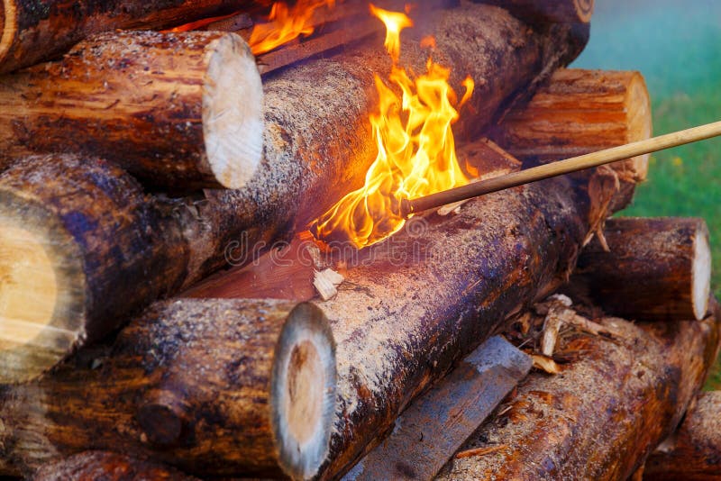 Setting Big Bonfire Made of Logs on Fire with Torch. Stock Image ...
