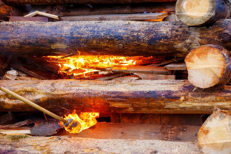 Setting Big Bonfire Made of Logs on Fire with Torch. Stock Image ...