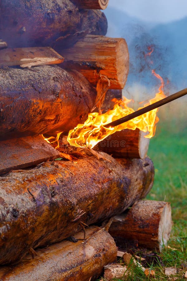 Setting Big Bonfire Made of Logs on Fire with Torch. Stock Image ...