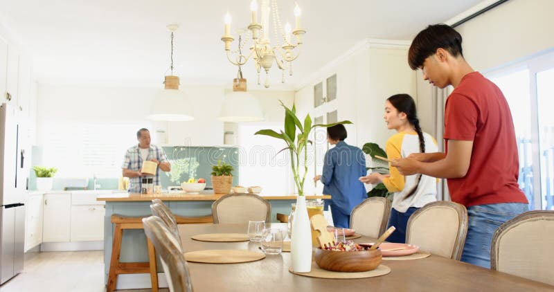 Setting Dining Table, Family Preparing for Meal in Modern Kitchen ...