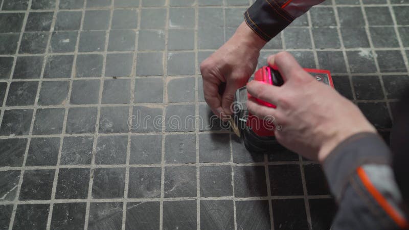 Setting the Laser Level. Ceramic Tiles and Tiler Tools. Worker Hand ...