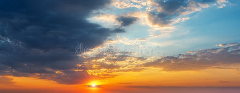 Setting Sun in the Orange Blue Evening Sky. Sun Rays Break through the ...