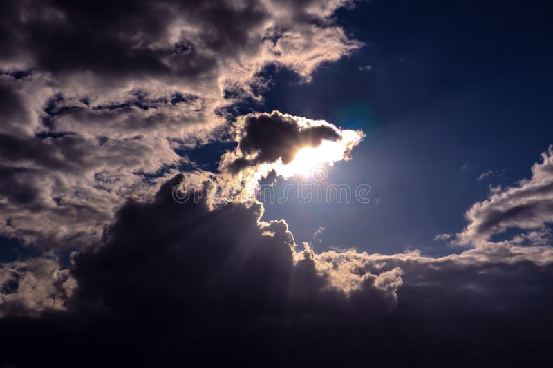 The Setting Sun Peeks through the Dark Blue Clouds Stock Image - Image ...