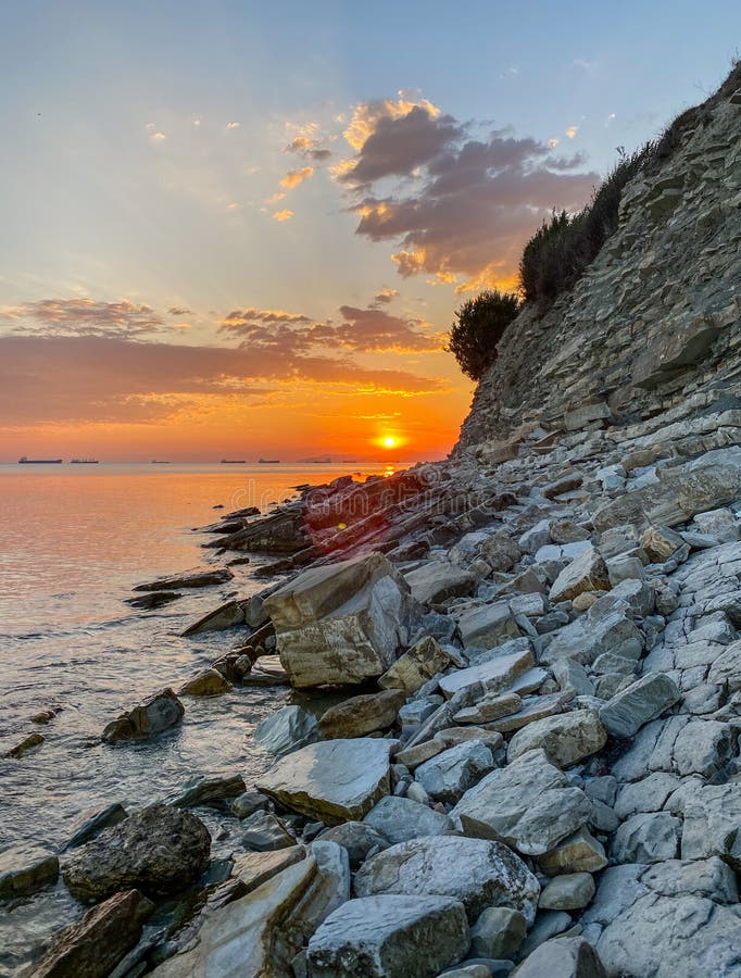 The Setting Sun on the Sea Rocky Shore in the Sea a Large Triangular ...