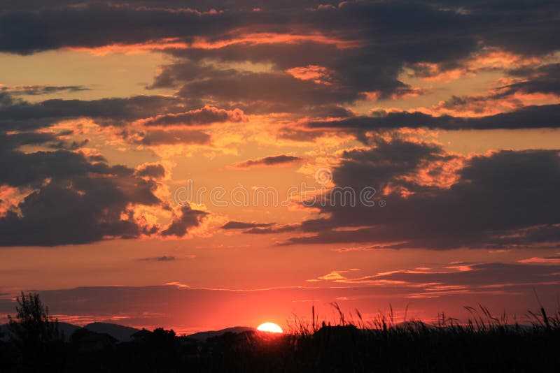 The Setting Sun Shines in a Red Cloudy Sky Stock Photo - Image of ...