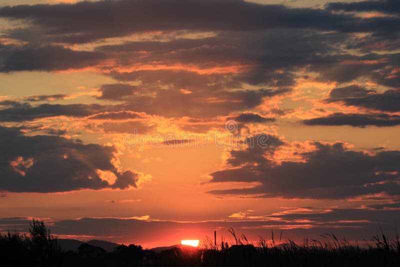 The Setting Sun Shines in a Red Cloudy Sky Stock Image - Image of ...