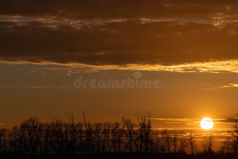 The Setting Sun Sinks Below the Horizon Stock Photo - Image of bare ...