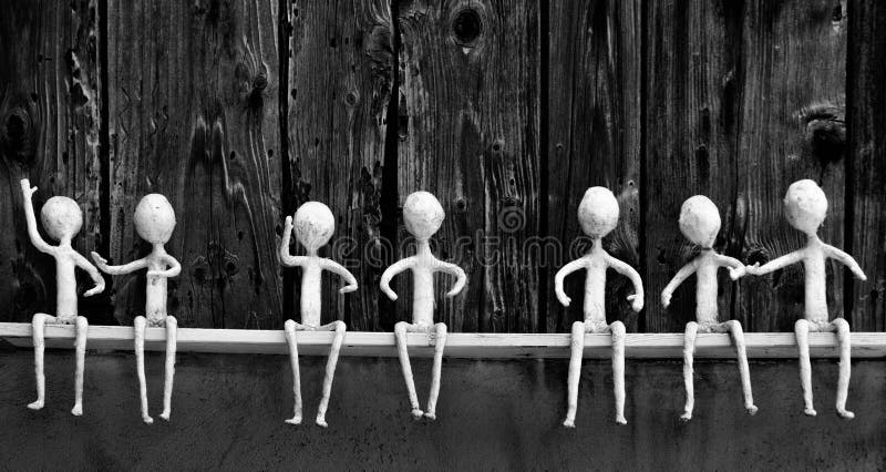 Seven White Figures Sitting on a Wooden Shelf in Various Poses Stock ...