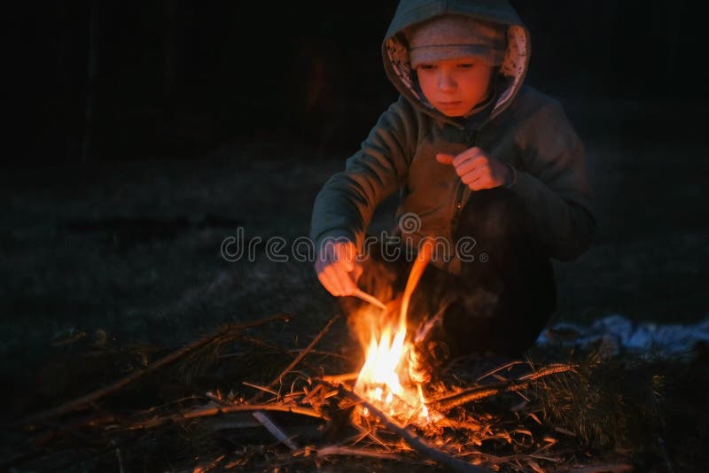 Seven-year-old Boy Light a Fire in the Woods. Stock Photo - Image of ...
