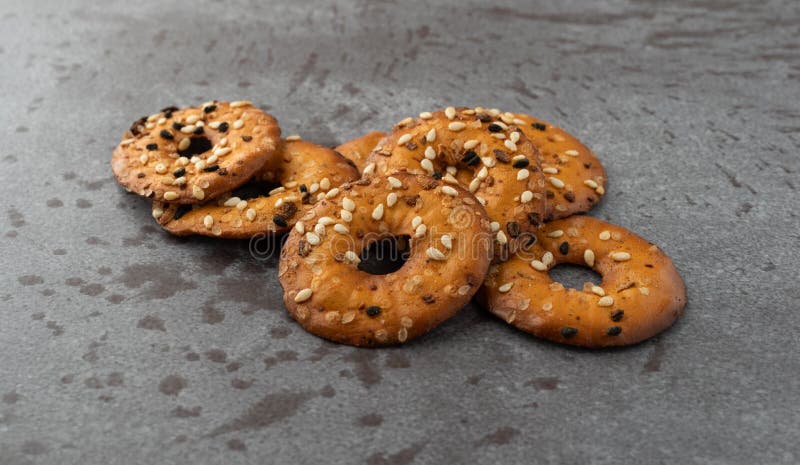 Several Bite Size Bagel Chips with Seeds on Gray Background Stock Photo ...