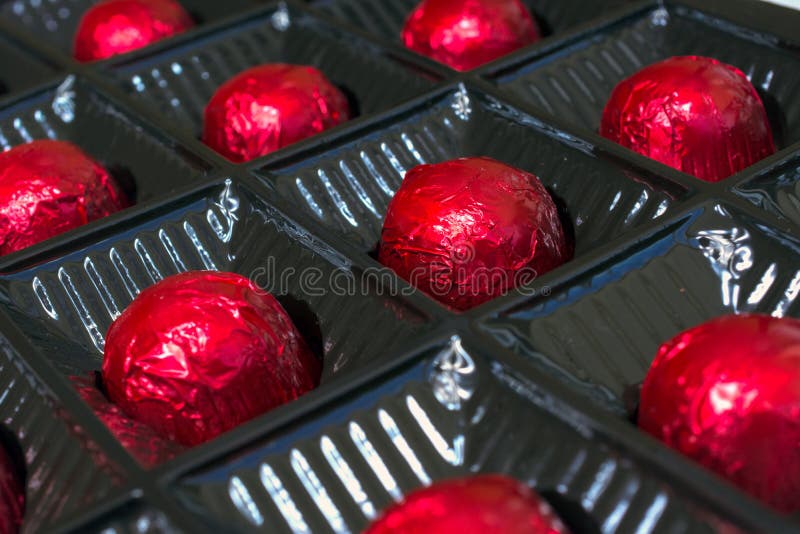 Several Chocolates in Red Foil Stock Photo - Image of sweets, foil ...