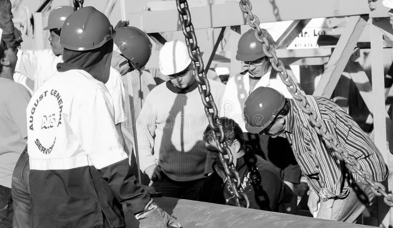 Several Construction Workers are Working at a Bridge As People Look on ...