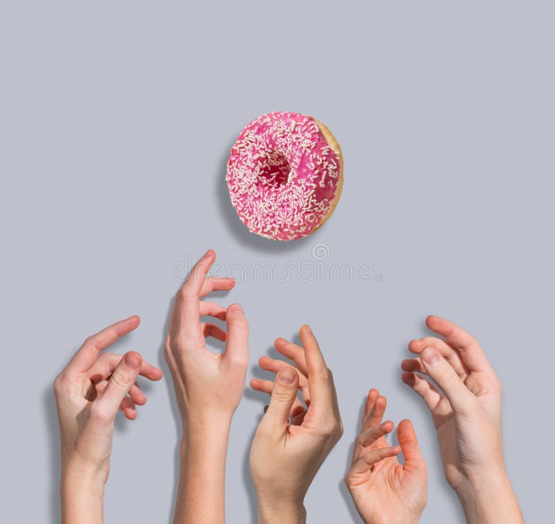 Several Hands Reach for a Levitating Glazed Pink Donut on Blue ...