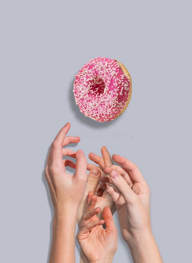 Several Hands Reach for a Levitating Glazed Pink Donut on Blue ...
