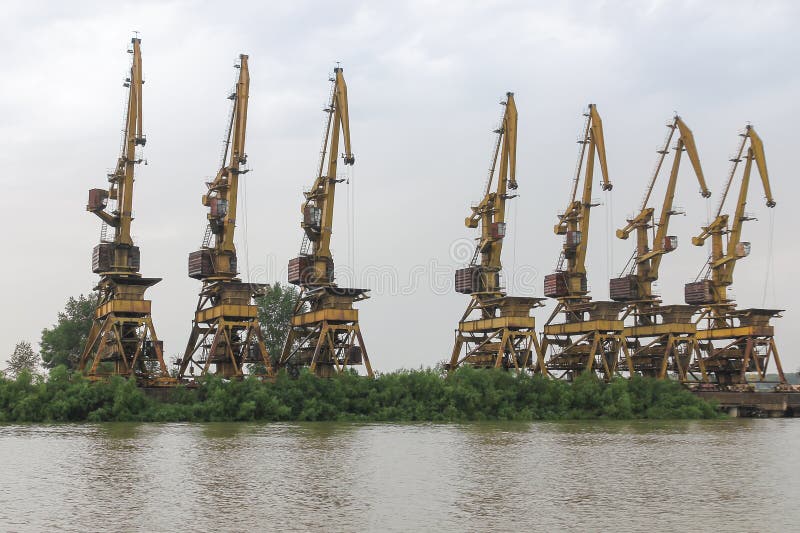 Several Old Rusty Gantry Cranes Stand in a Row on an Overgrown River ...
