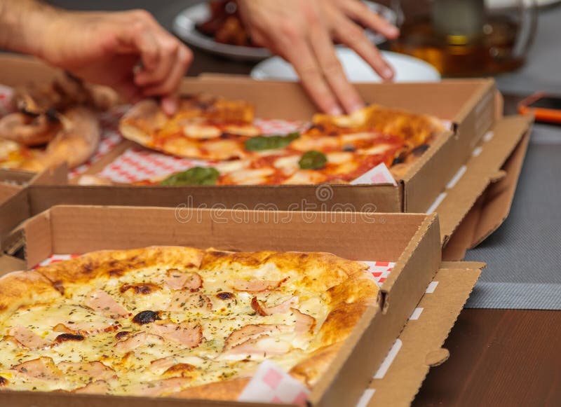 Several Pizzas in Cardboard Boxes are Sitting on a Table Stock Photo ...
