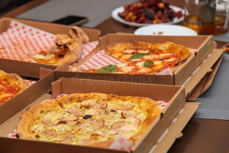 Several Pizzas in Cardboard Boxes are Sitting on a Table Stock Image ...